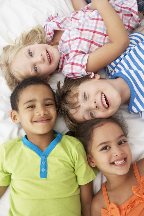 Overhead View of Four Children Playing on Bed Together Stock Image ...