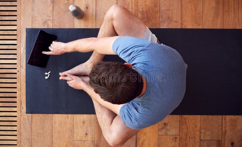 Overhead View of Man Sitting on Exercise Mat Using Digital Tablet Stock ...
