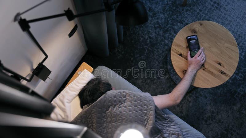 Overhead View of a Man Sleeping with a Phone Ringing on the Nightstand ...