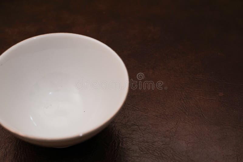 Overhead View of a Mini White Ceramic Bowl on a Brown Background Stock ...