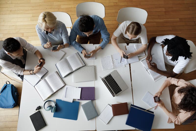 Overhead View Multiethnic Students Sit at Table Use Smartphones Stock ...