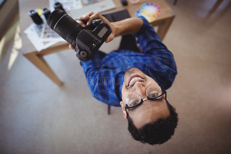 Overhead View of Smiling Executive Holding Digital Camera at Desk Stock ...
