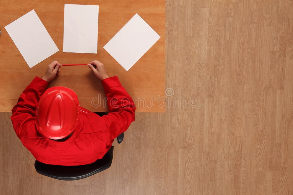 Overhead View of Worker in Red Uniform and Hardhat Reading Papers Stock ...