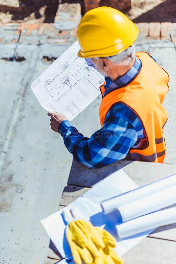 Overhead View of Worker in Reflective Vest and Hardhat Examining ...