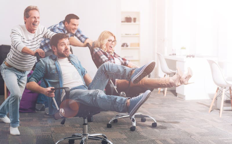 Overjoyed Colleagues Riding in Office Chairs Stock Image - Image of ...