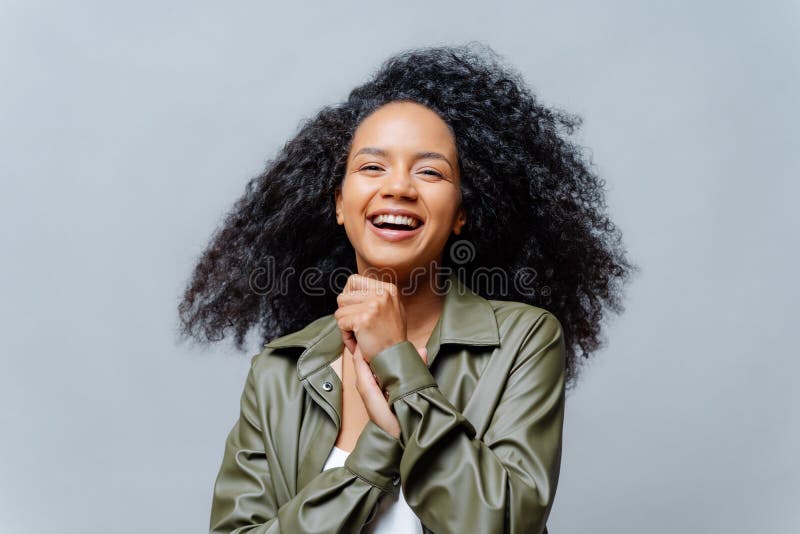 Overjoyed Dark Skinned Curly Woman Laughs Happily Laughs At Funny Joke