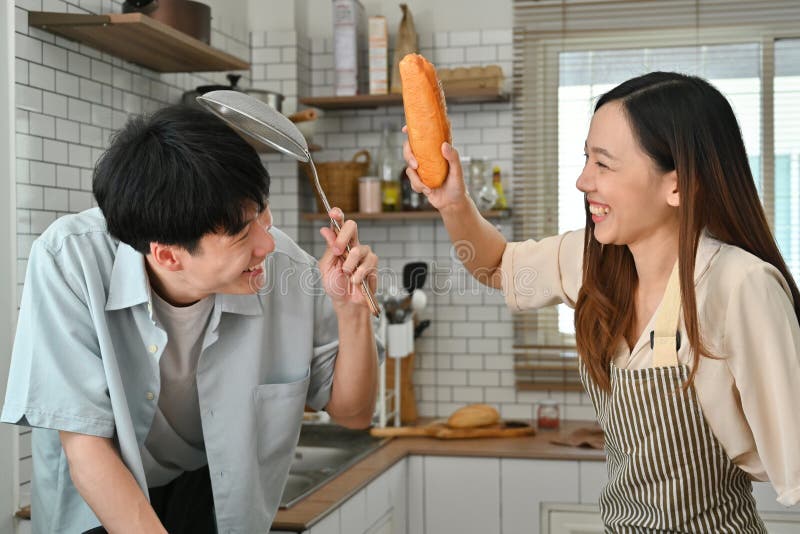 Overjoyed Married Couple Using Kitchenware and Bread Baguettes Fighting ...