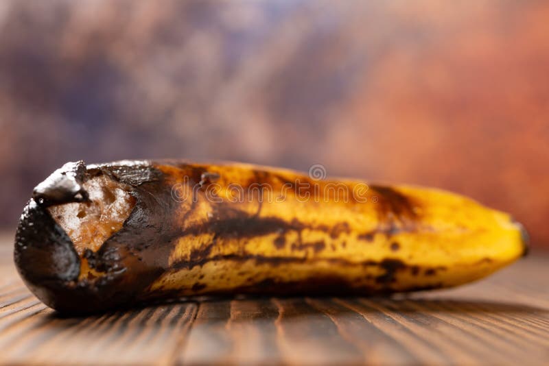 Overripe Banana with the Tip Damaged on Wood Table Stock Photo - Image ...