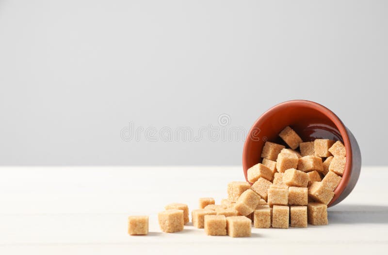Overturned Bowl with Brown Sugar Cubes on White Wooden Table, Space for ...