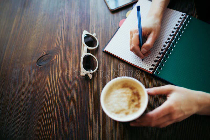 Overview of Woman`s Hands Writing in a Notepad, Holding Coffee. Stock ...