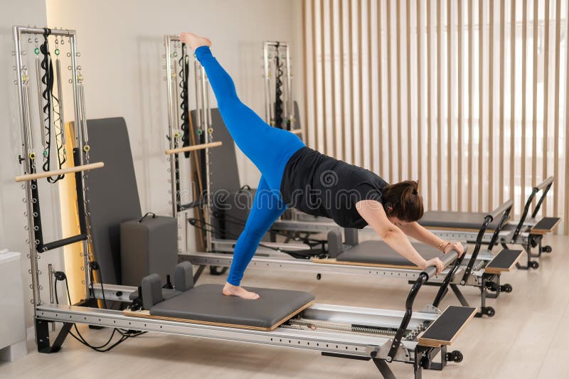 Overweight Caucasian Woman Doing Pilates Exercises on a Reformer. Stock ... Overweight Caucasian Woman Doing Pilates Exercises on a Reformer. Stock ...