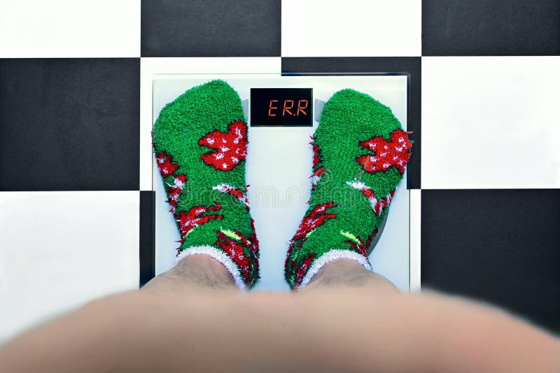 Overweight Man Looks at a Error Sign of a Weighting Scale. Stock Photo ...