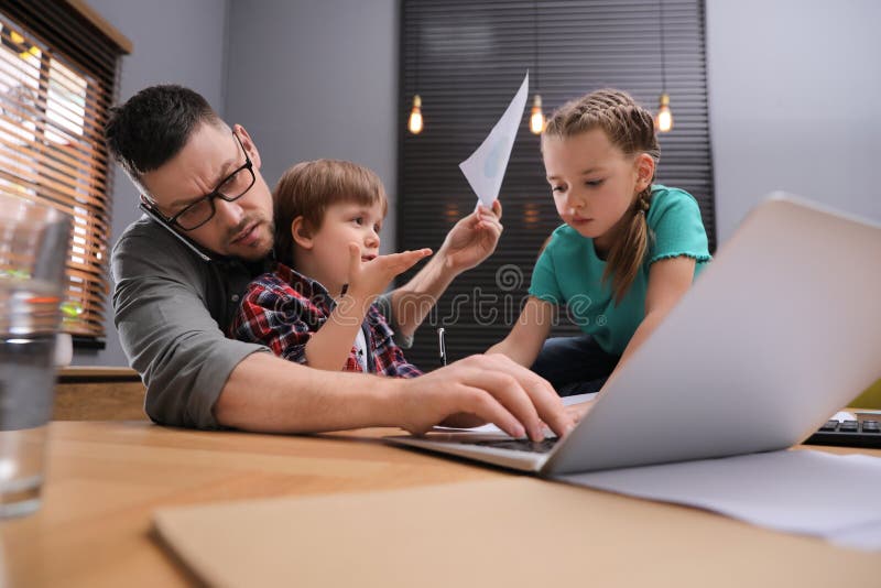 Overwhelmed Man Combining Parenting and Work at Home Stock Image ...