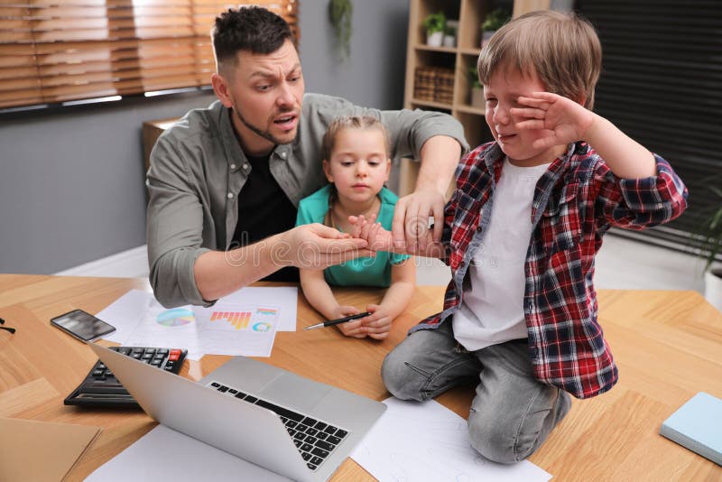 Overwhelmed Man Combining Parenting and Work at Home Stock Photo ...