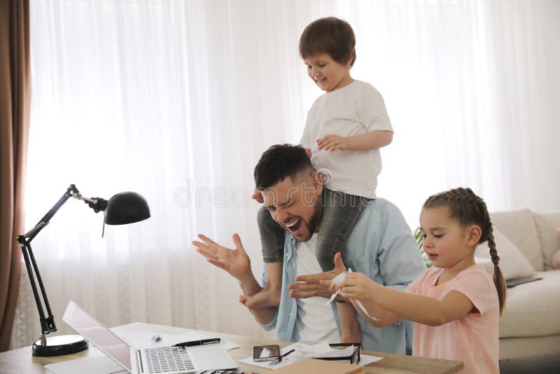Overwhelmed Man Combining Parenting and Work at Home Stock Image ...