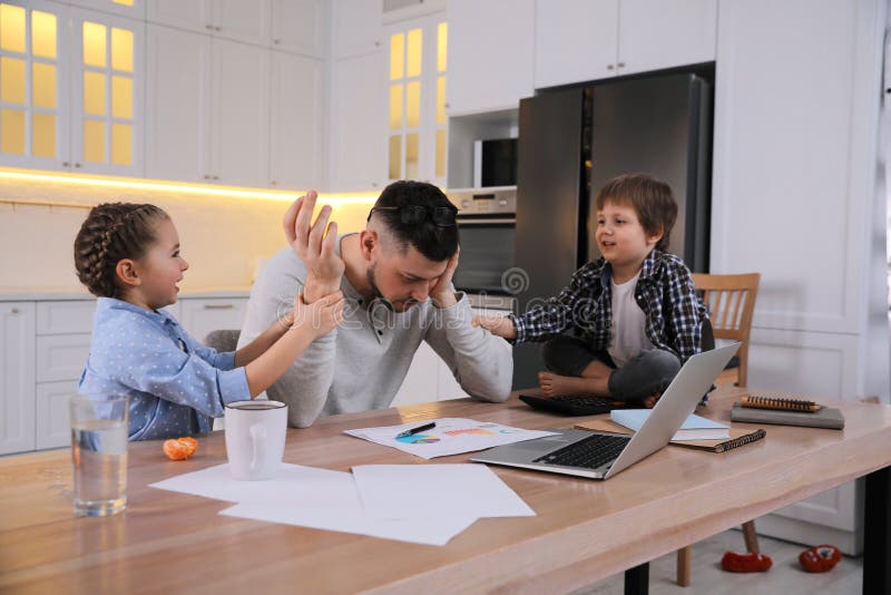 Overwhelmed Man Combining Parenting and Work at Home Stock Photo ...