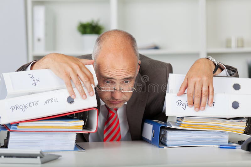 Overworked Businessman Leaning on Stack of Binders Stock Image - Image ...