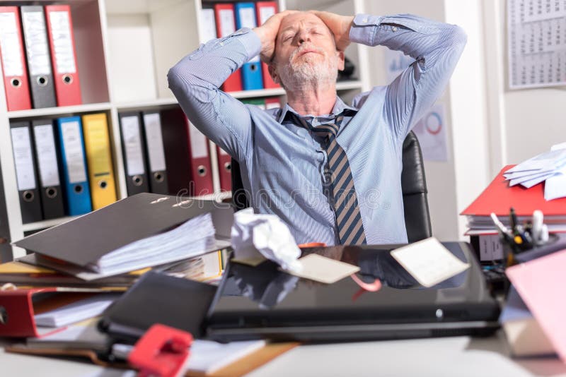 Overworked Businessman Sitting at a Messy Desk Stock Photo - Image of ...