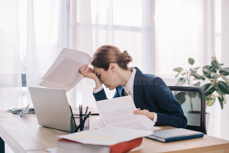 Overworked Businesswoman in Suit with Papers in Hands at Workplace ...