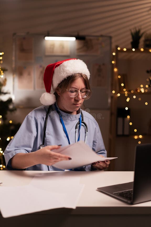 Overworked Sad Nurse or Doctor Reading Documents, Doing Paperwork while ...