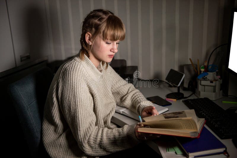 An Overworked Student Sits at Night with a Book. Make Notes in a ...