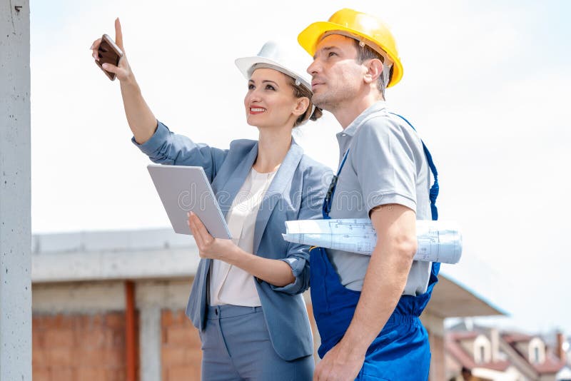Owner and Worker on Construction Site Reading Blueprint Plan Stock ...