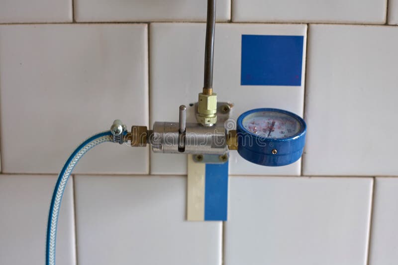 The Oxygen Reducer is Mounted on the Wall. an Oxygen Hose is Connected ...