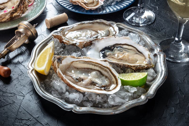 Oysters on Ice at a Restaurant, with Lemon, Lime, and White Wine, on ...