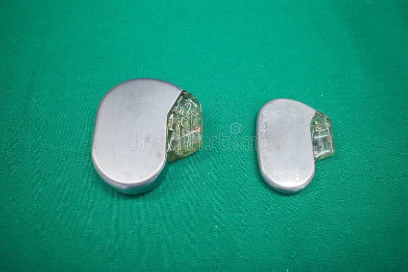 Pacemaker Lies Directly Next To a Defibrillator on a Green Surgical ...