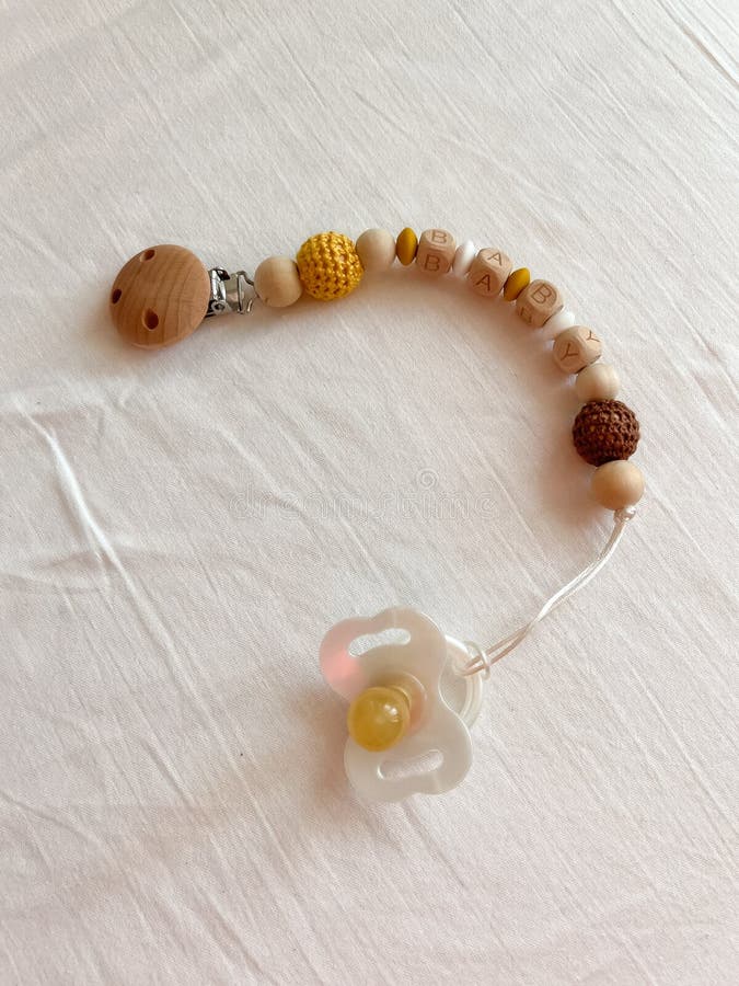 A Pacifier Holder Made of Wooden Beads with a Clothespin and a Pacifier ...