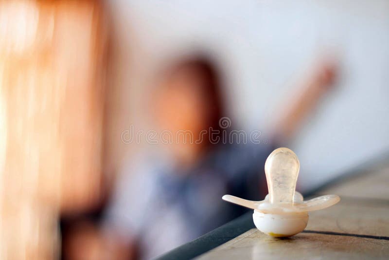 Pacifier on a Table Next To a Child. Stock Photo - Image of table, kids ...
