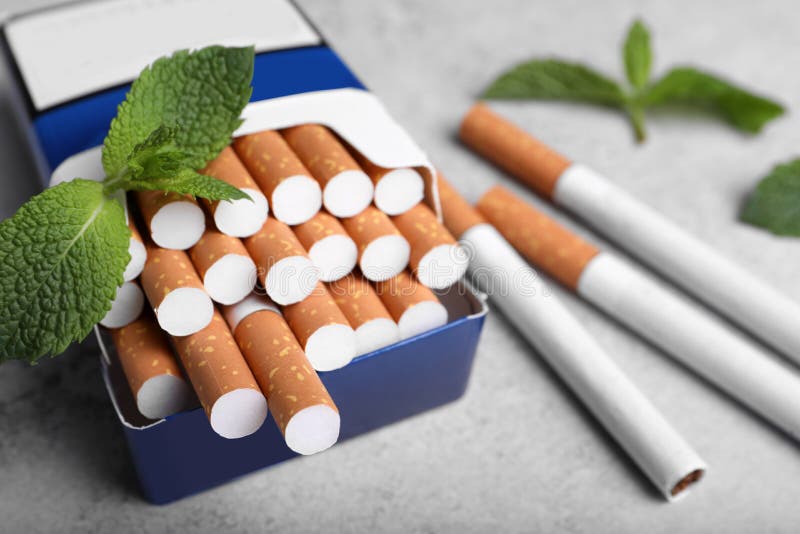 Pack of Menthol Cigarettes and Mint Leaves on Grey Table, Closeup Stock ...