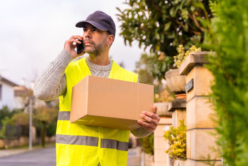 Package Delivery Carrier with a Box from an Online Store, Calling the ...