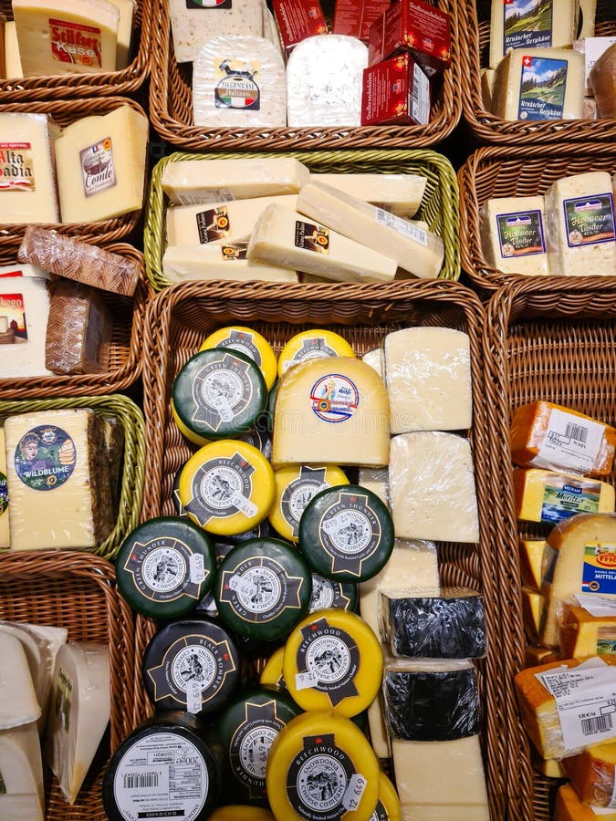 Packaged Varieties of Cheese in Display with Baskets in a Supermarket ...