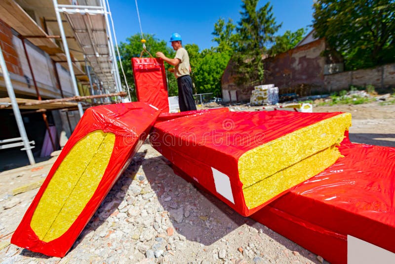 Packages with Stone Wool Arranged in a Pile, the Workman is Hanging the ...