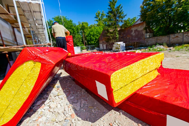 Packages with Stone Wool Arranged in a Pile, the Workman is Hanging the ...