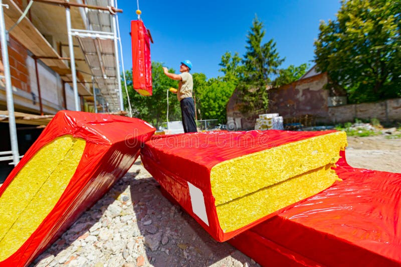 Packages with Stone Wool Arranged in a Pile, the Workman is Hanging the ...