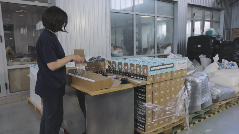 Packaging of Finished Goods in a Box. Workers Pack Finished Products ...