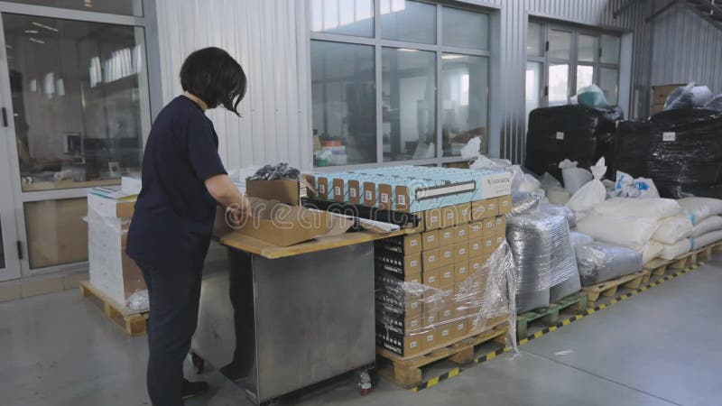 Workers Pack Finished Products into a Box. Packaging of Finished Goods ...