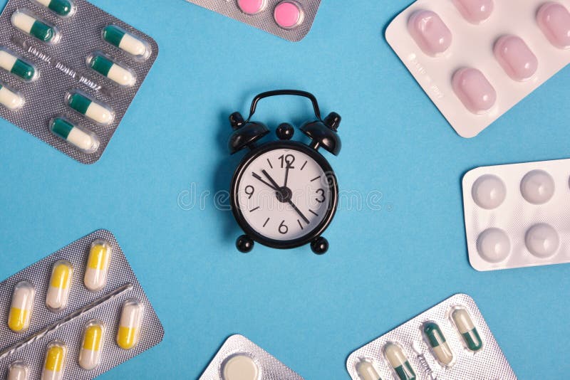 Packaging of Tablets and Pills on the Table with Clock in the Middle ...
