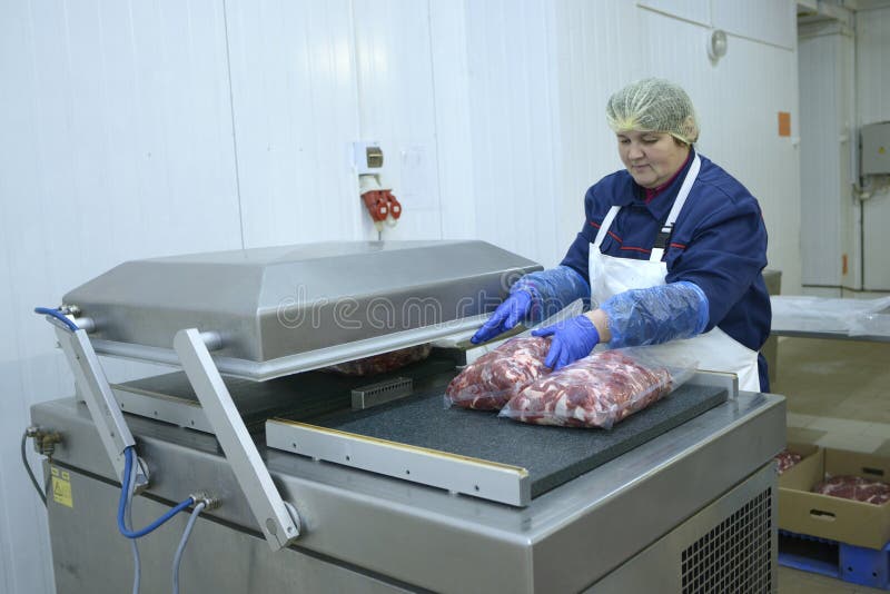 At the Packaging Workshop: Woman Worker Packing Pieces of Meat Vacuum ...