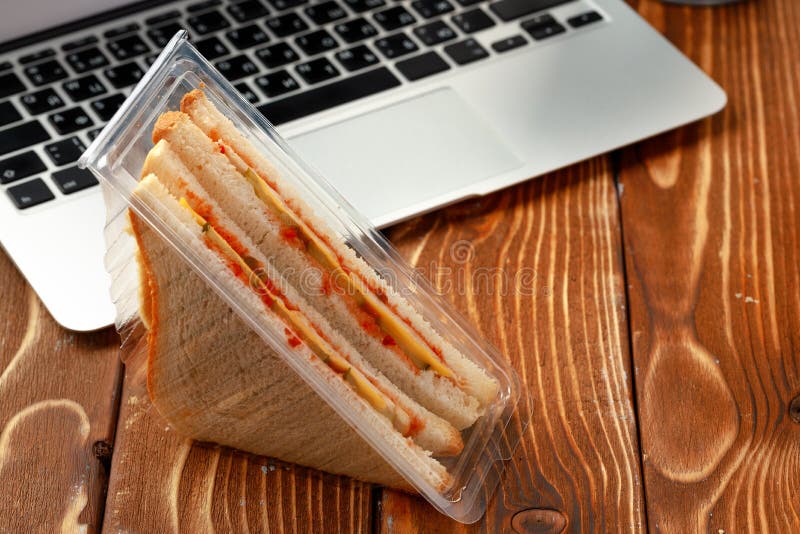 Packed Sandwich and Open Laptop on Brown Wooden Table Stock Image ...