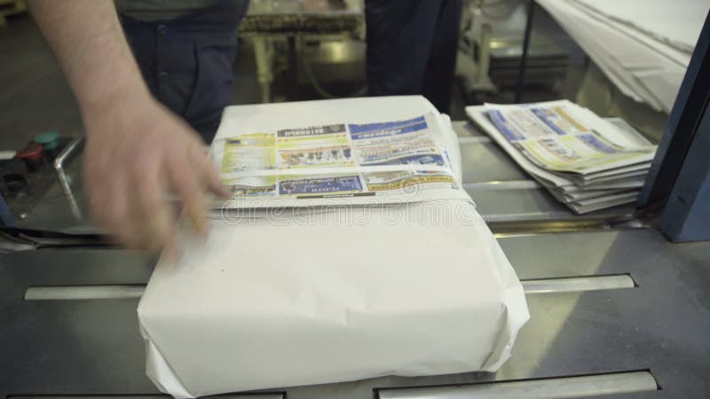 Packer Puts Stack of Newspapers in Wrapping Paper Packaging Indoors ...