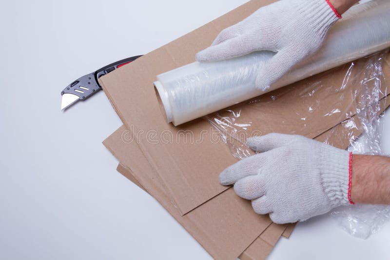 Packing the Goods in a Cardboard Box and Stretch Film. Tools for ...