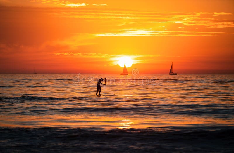 Paddle Boarding. People on Paddle Boat on Sea at Sunset. Stock Photo ...