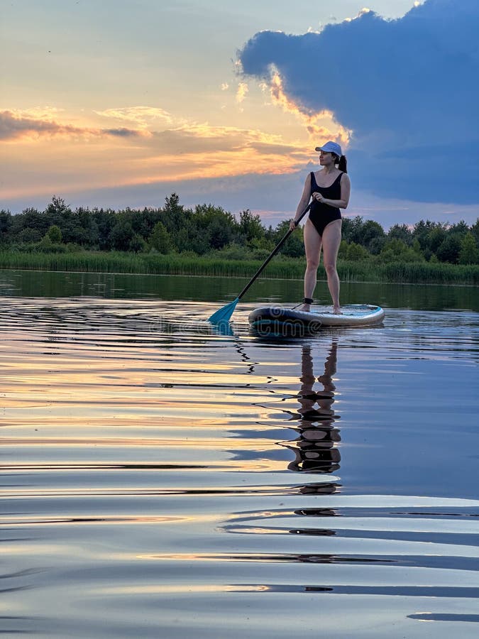 Paddleboarding at Sunset on a Tranquil Lake Stock Image - Image of ...