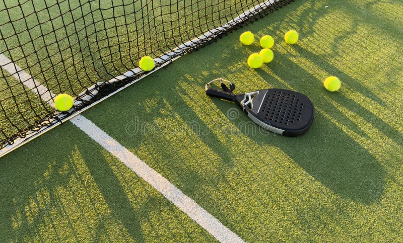 Padel Racket and Padel Ball on a Green Court in the Sunset Stock Image ...