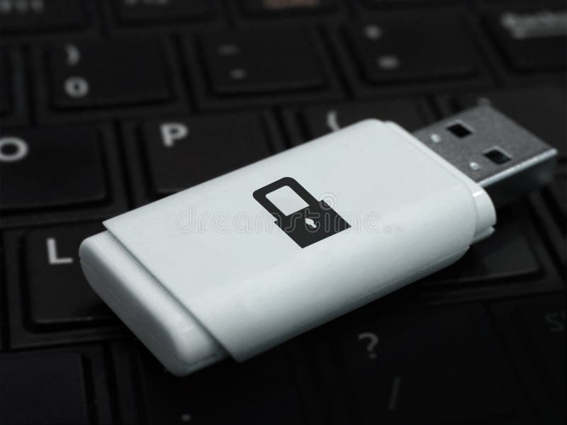 A White USB Flash Drive with a Padlock Icon, on a Computer Keyboard ...