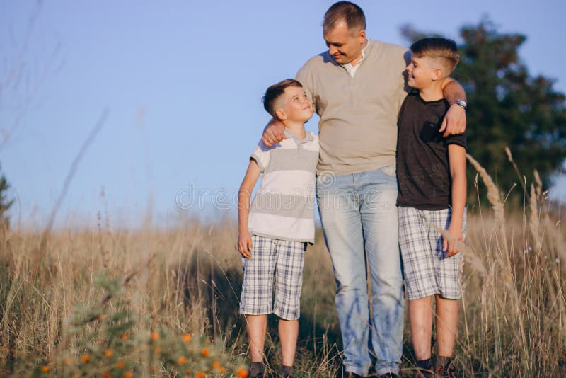 Padre con dos hijos foto de archivo. Imagen de campo - 123191198
