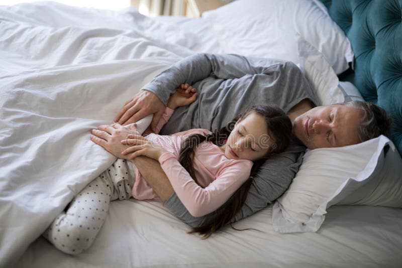 Padre E Hija Que Duermen Junto En Cama En Dormitorio Imagen de archivo ...